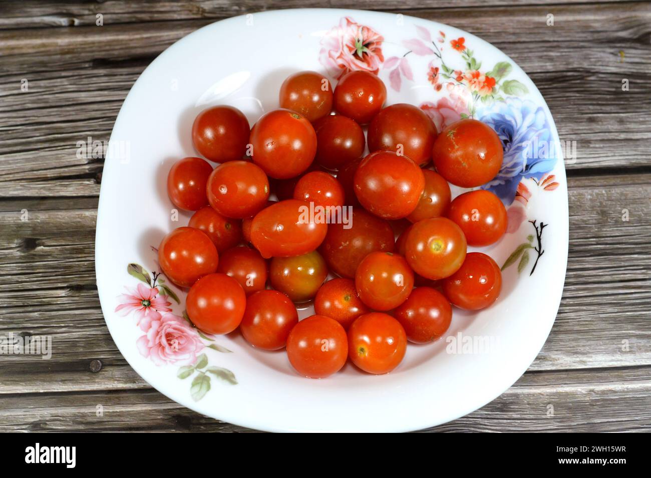 The cherry tomato, a type of small round tomato believed to be an ...