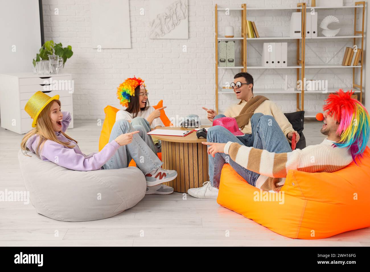 Business colleagues with funny disguise laughing in office. April Fools ...