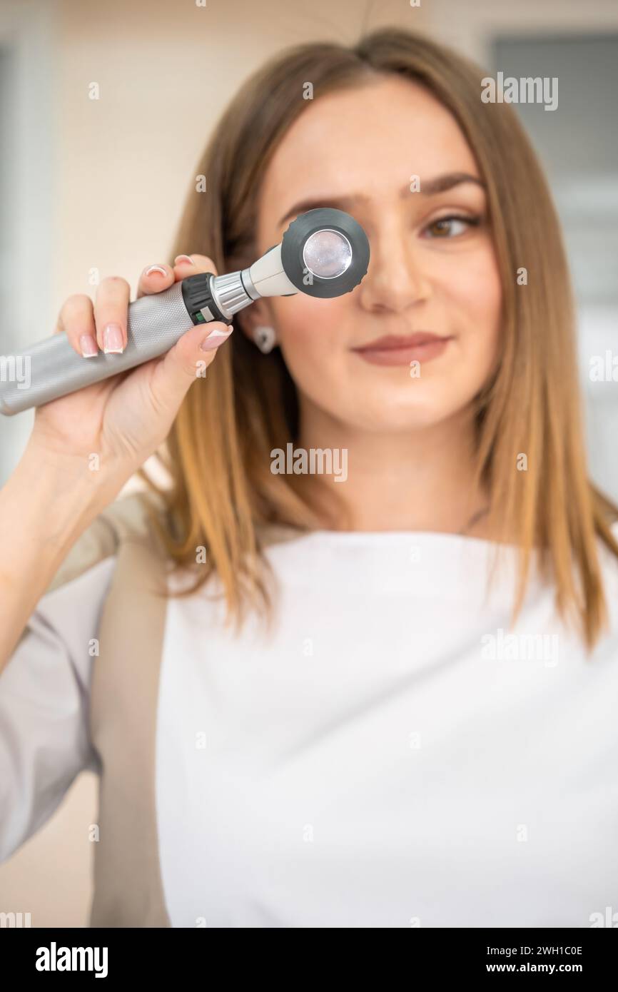 Portrait of blonde woman dermatologist with dermatoscope in uniform and ...