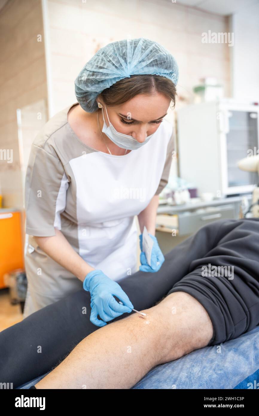 Medical female worker doing wound treatment and removing stitches Stock ...