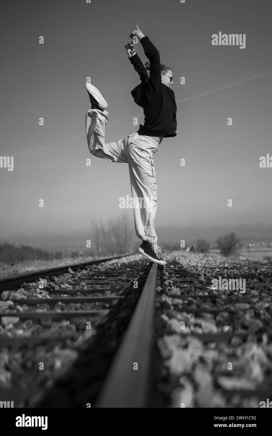 Ballet scene of female dancer in urban clothing on rail track in ...
