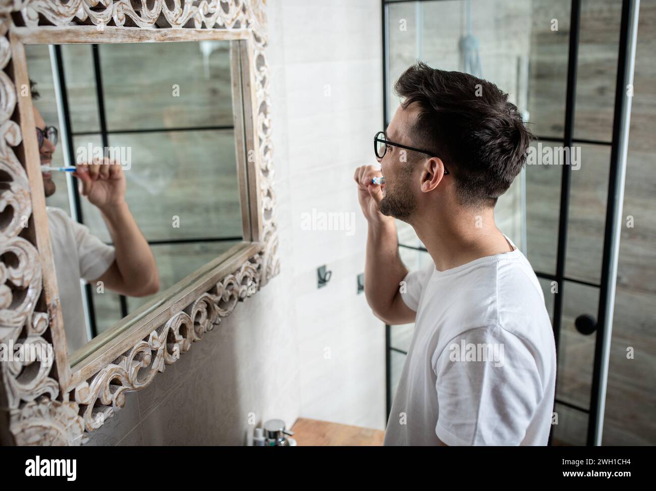 Man going through morning routine in the bathroom brushing teeth Stock ...