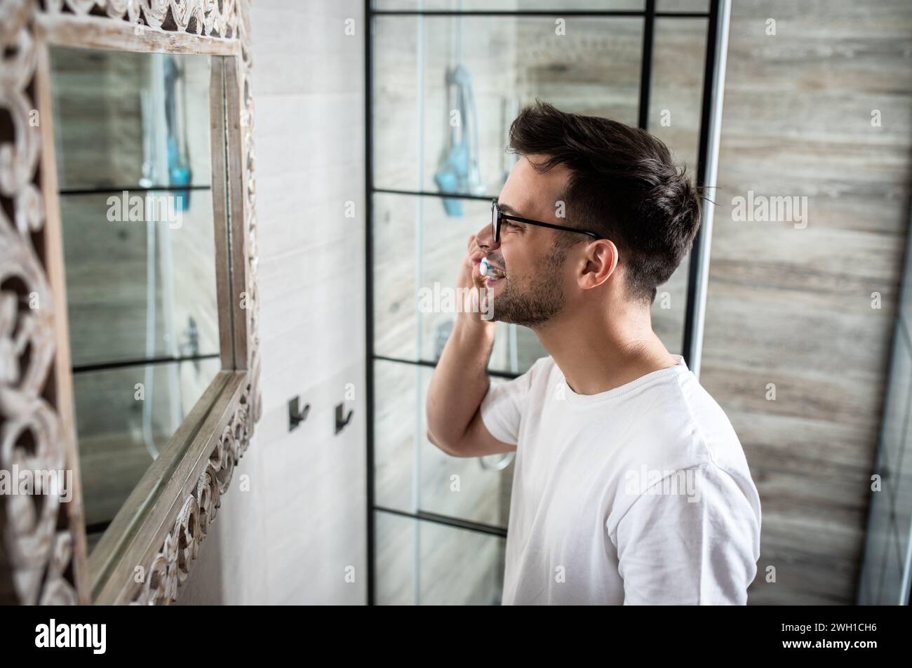 Man going through morning routine in the bathroom brushing teeth Stock ...