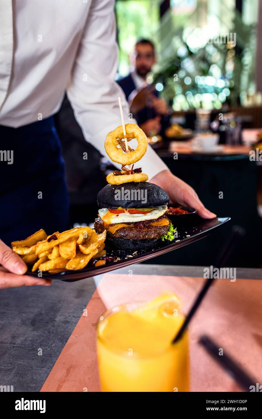 Close up of waitress hand serving meal in restaurant Stock Photo - Alamy