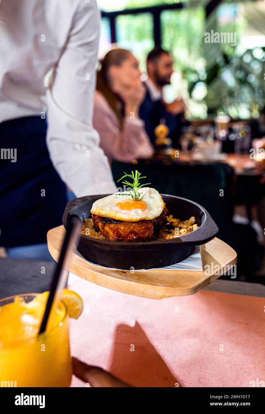 Close up of waitress hand serving meal in restaurant Stock Photo - Alamy