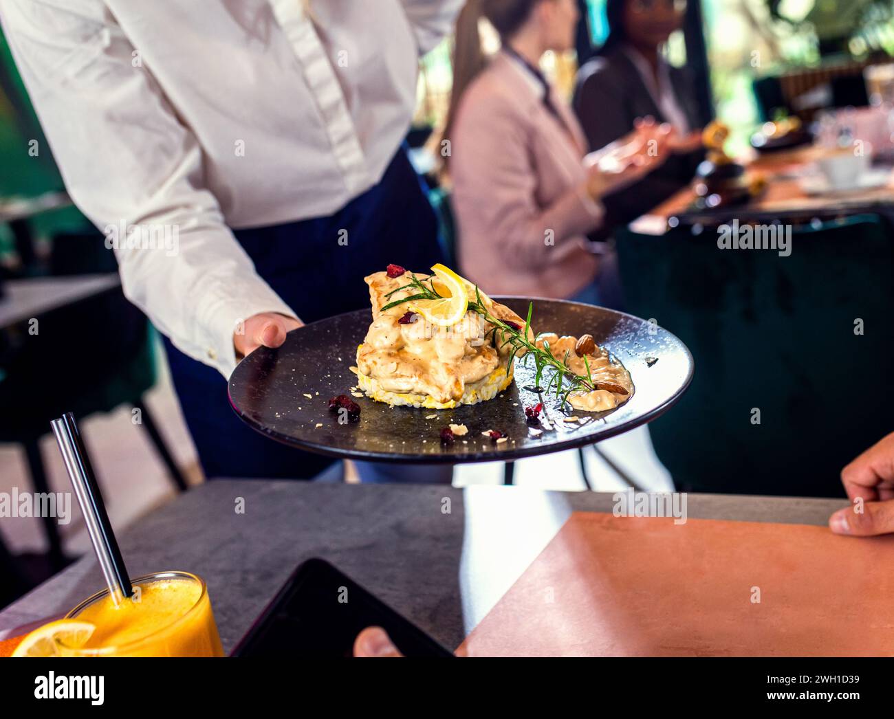 Close up of waitress hand serving meal in restaurant Stock Photo - Alamy