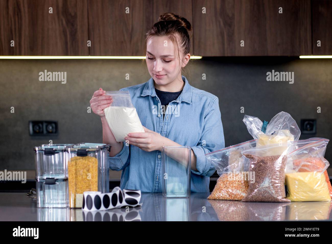 A woman uses containers to organize food in the kitchen. Layout and ...