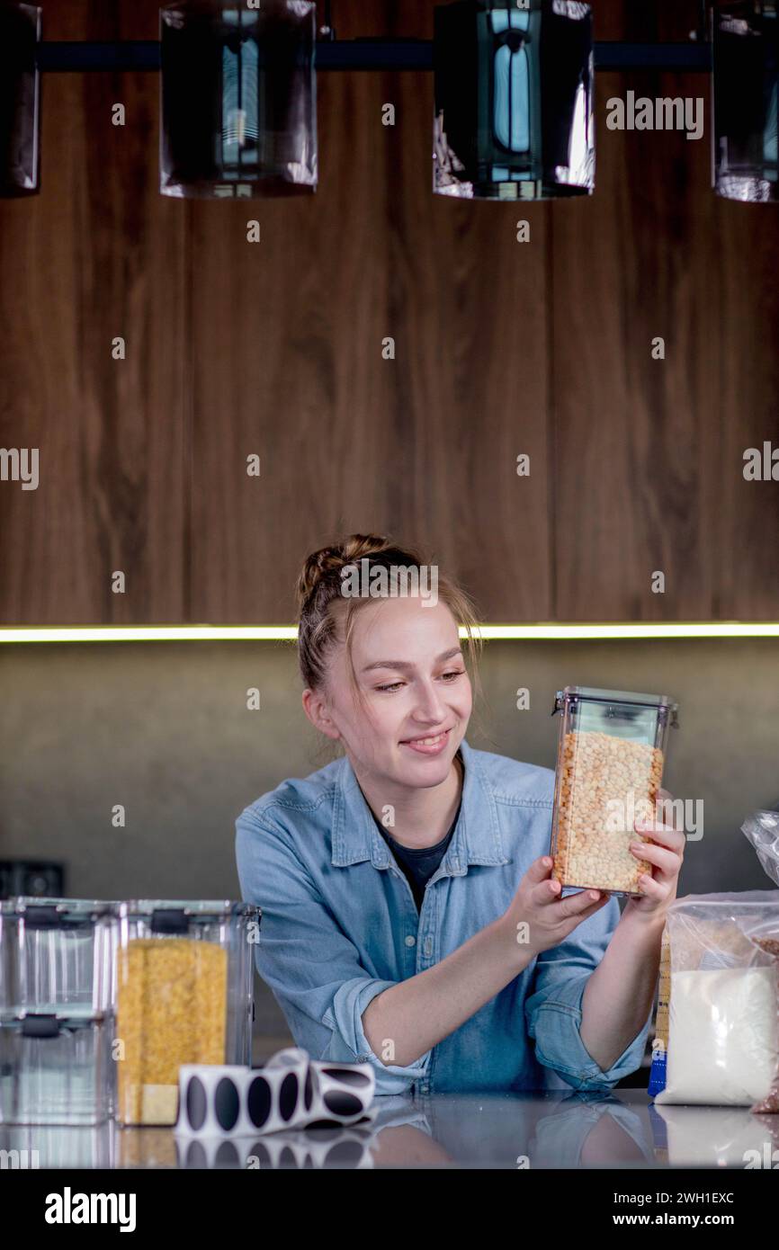 A woman uses containers to organize food in the kitchen. Layout and ...