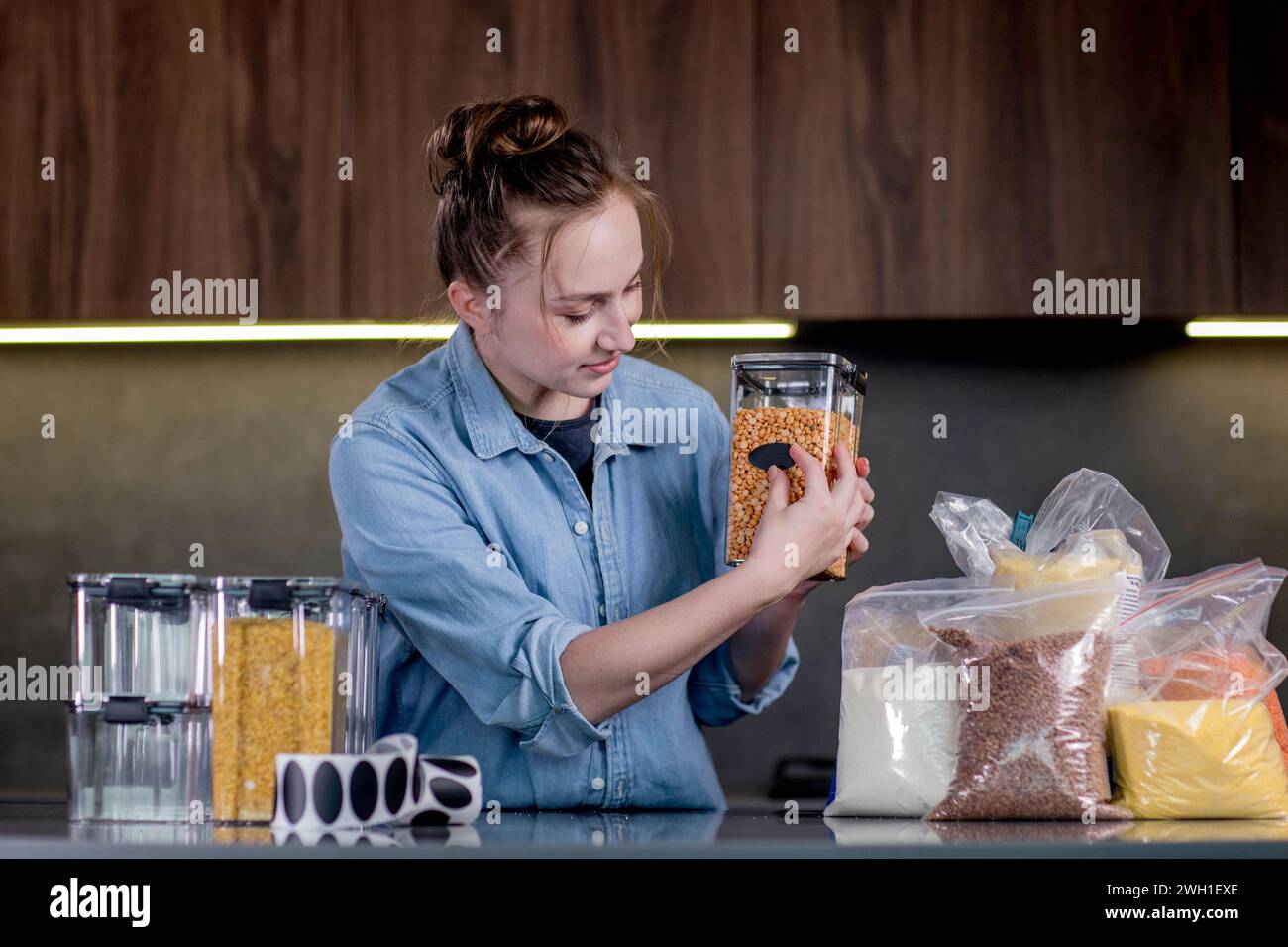 Nice woman organizes the placement of food in plastic cans. Woman signs ...