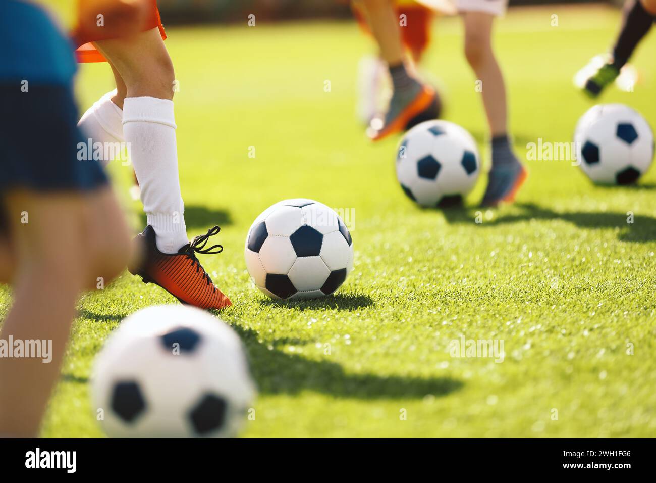 Boys kick football balls. Children attending outdoor soccer class ...