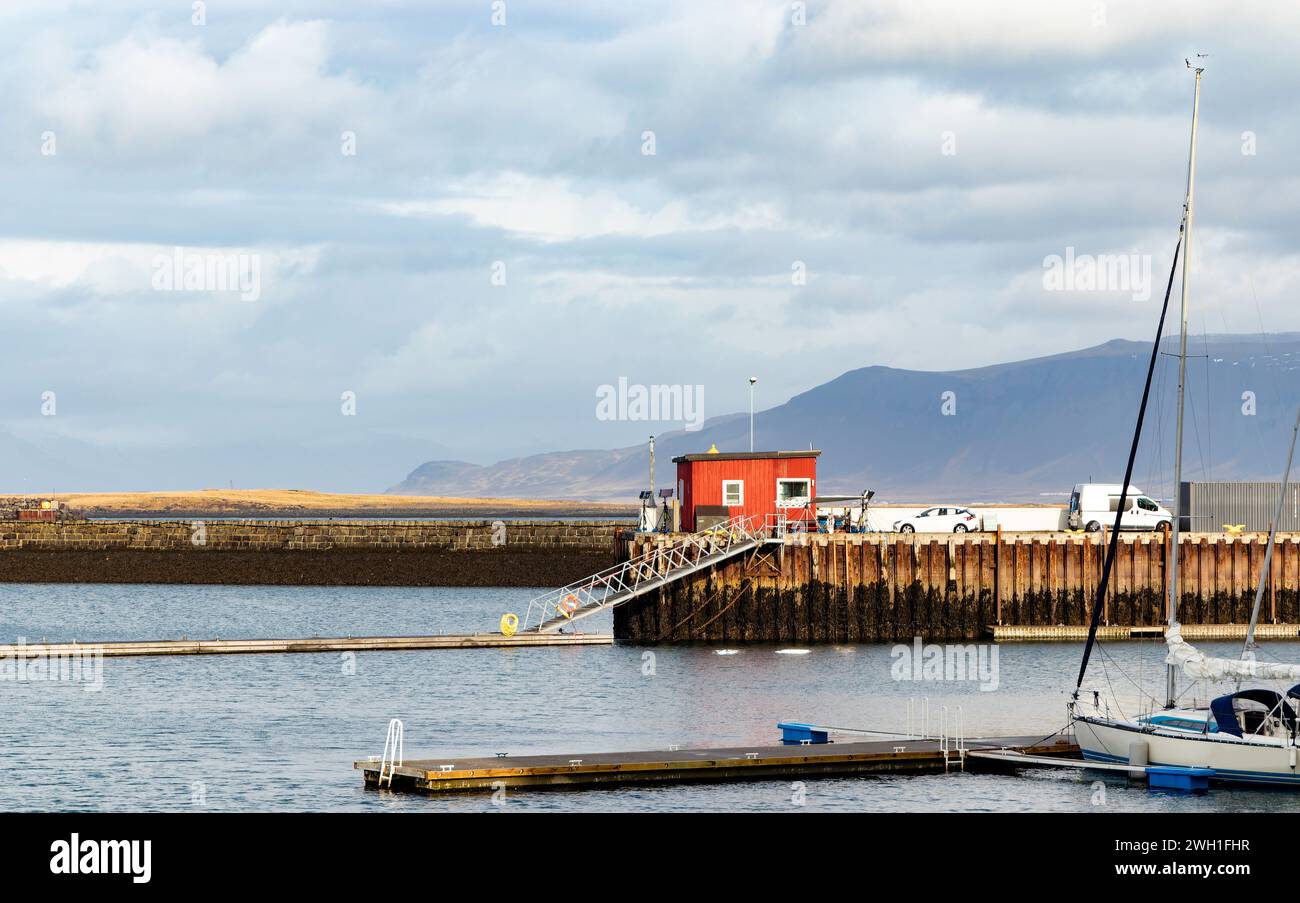 Pier with security cabin and ladder while vehicles parked on embankment ...