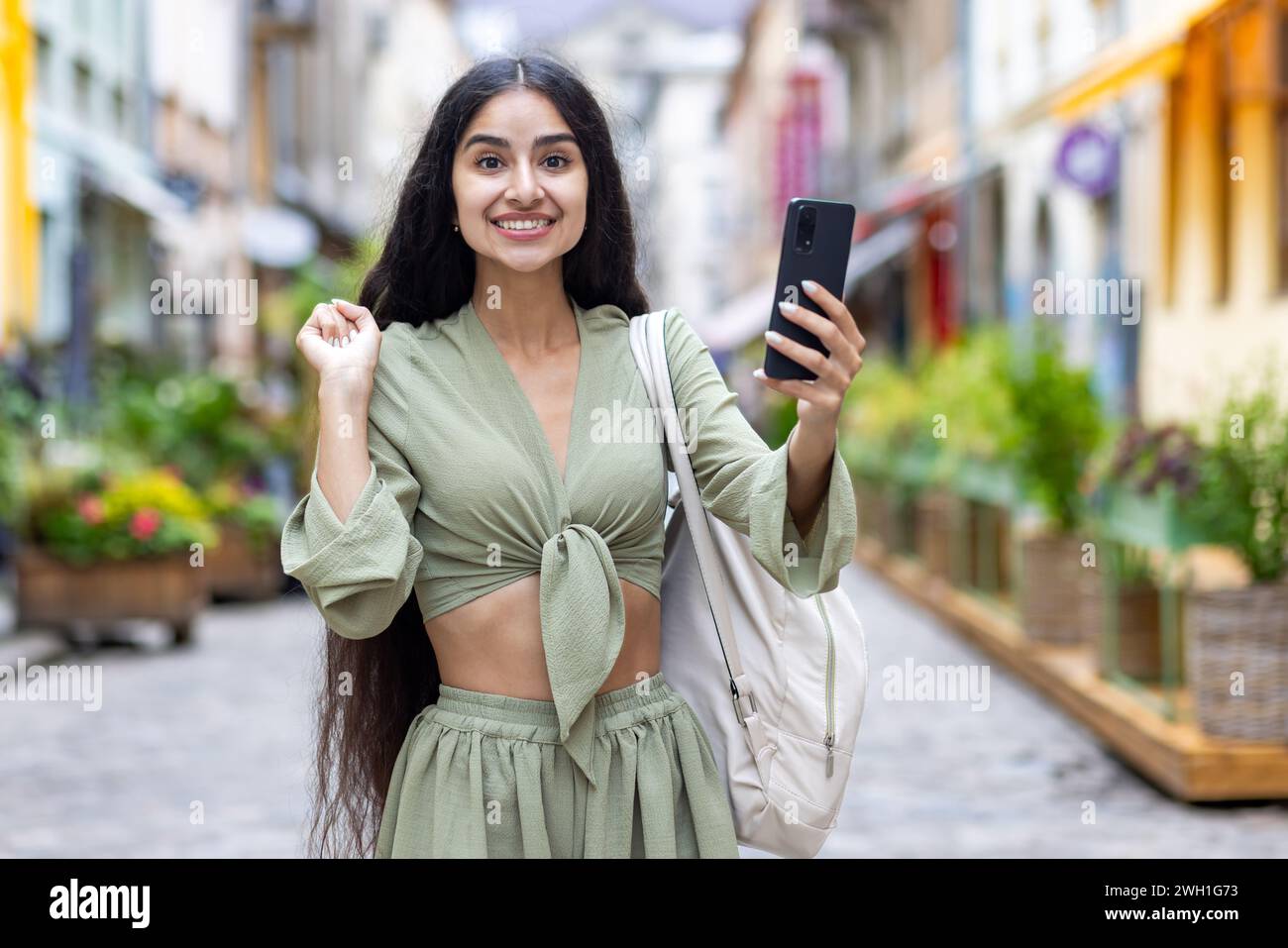 A young Indian woman tours a quaint urban street, her joyful expression ...