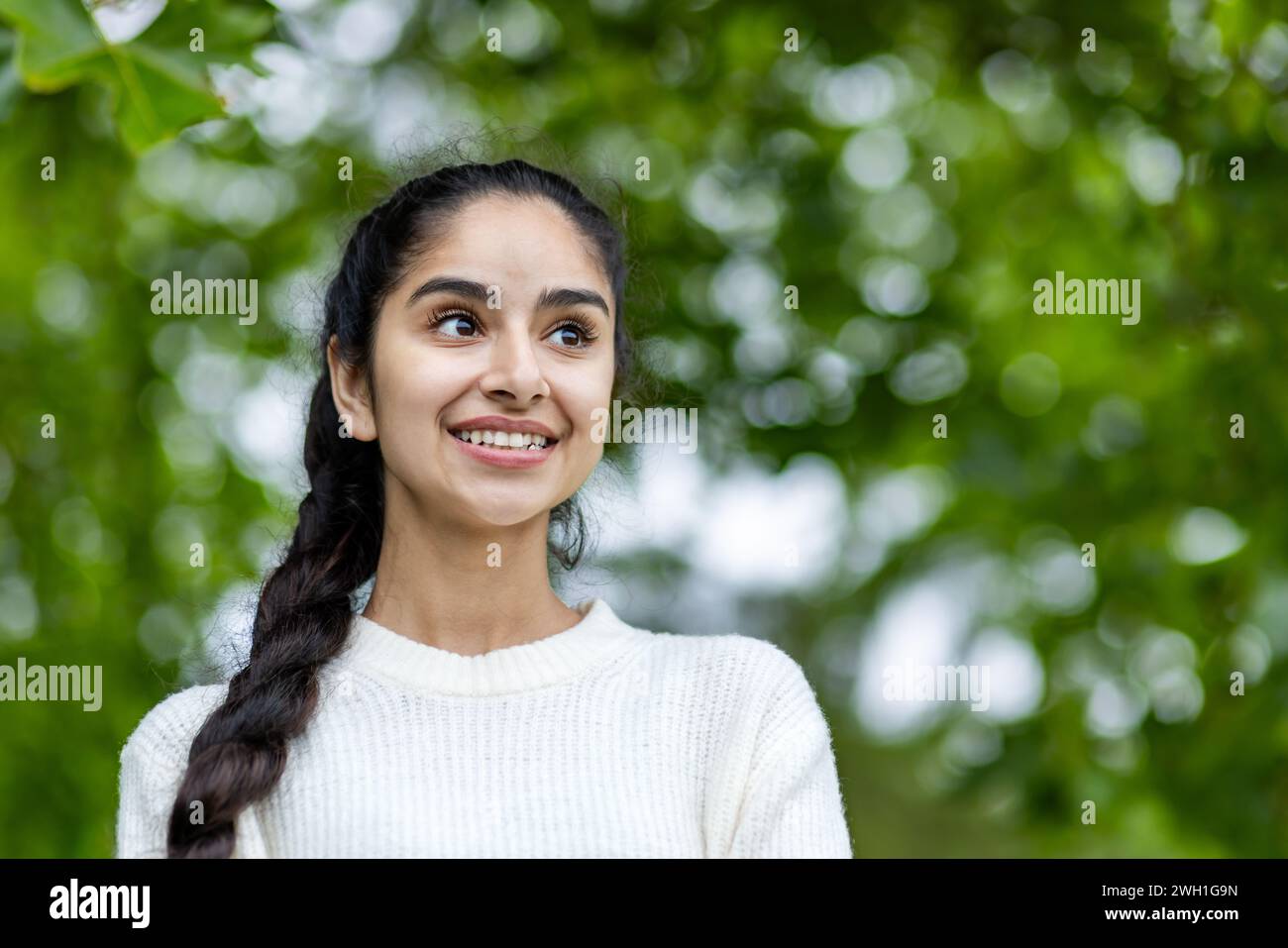 A radiant young Indian woman with a beautiful smile joyfully walking in ...