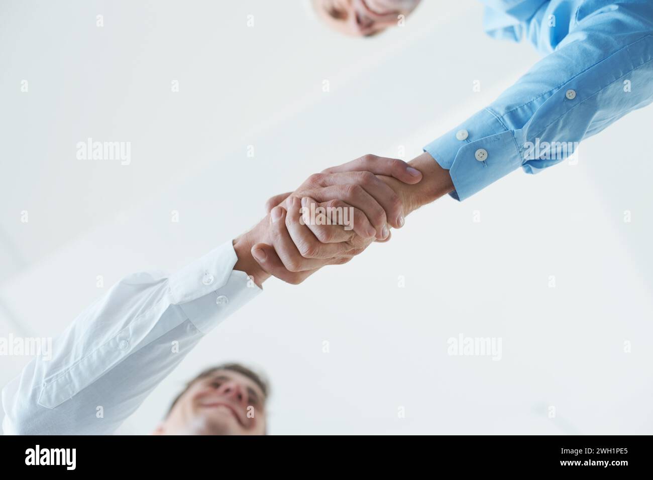 Low angle, business people and handshake with partnership, teamwork and agreement. Staff ...