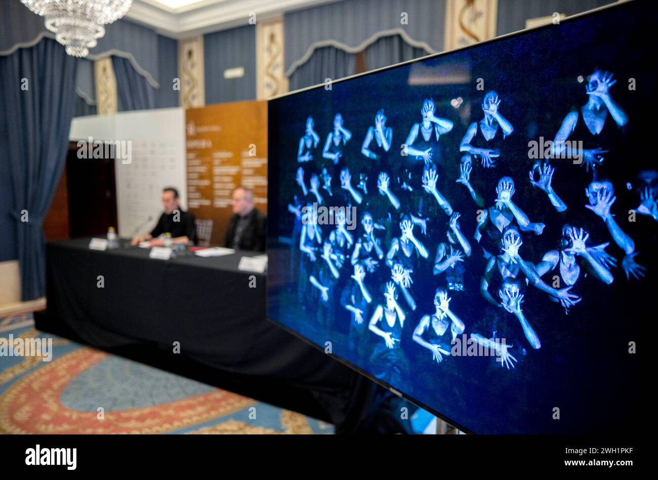 A screen shows several dancers during the presentation of the premiere ...