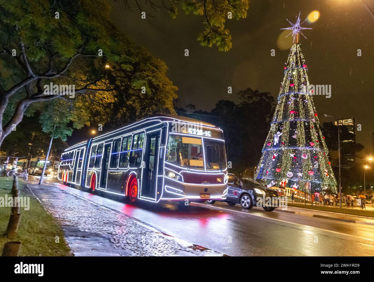 night view of a bus with Christmas decorations, passing in front of the ...