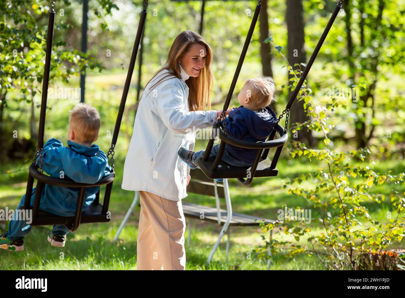 The mother with two children is having a fun time at the playground ...