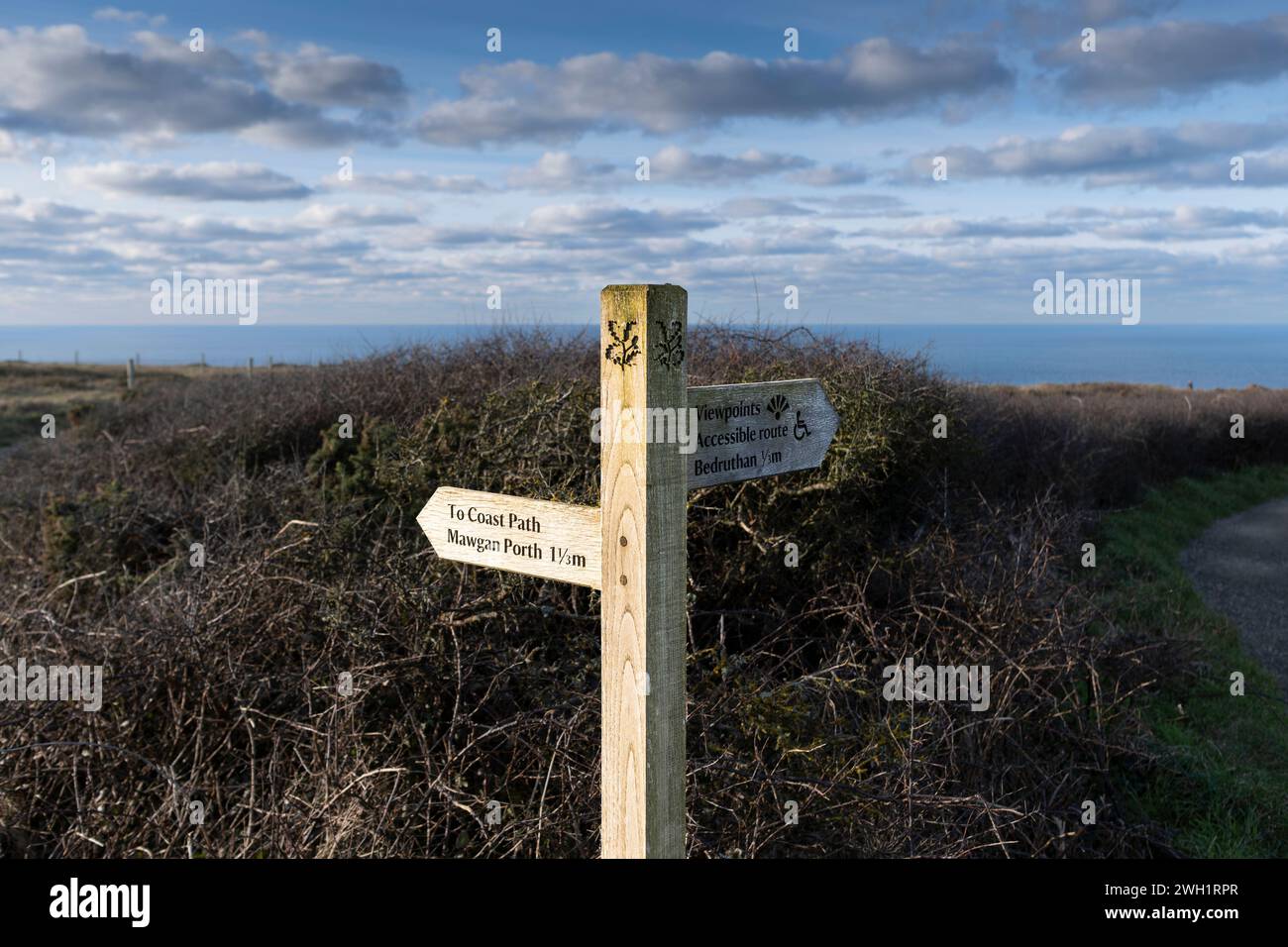 A wooden signpost giving directions to the coast path on the North ...
