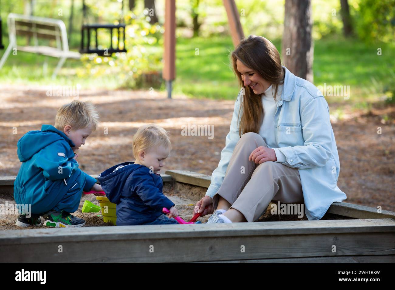 The mother with two children is having a fun time at the playground ...