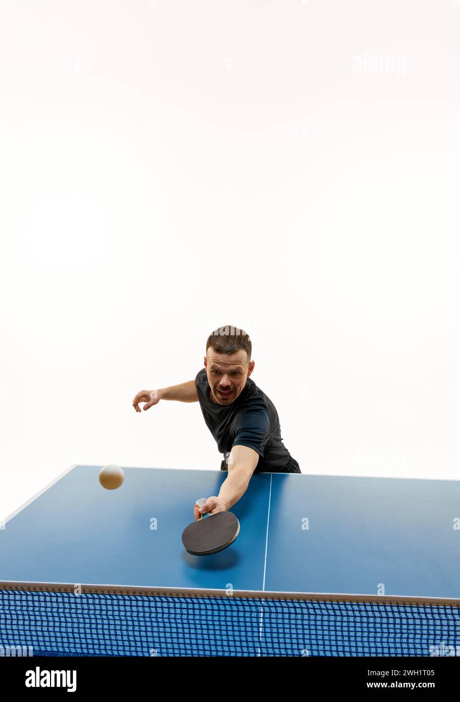 Dynamic shot of athletic, man table tennis player hitting ball in ...