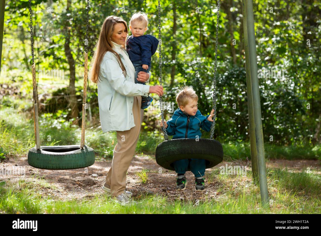 The mother with two children is having a fun time at the playground ...