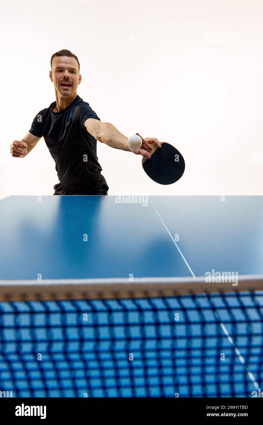 Dynamic portrait of athletic concentrated man training hits ball ...