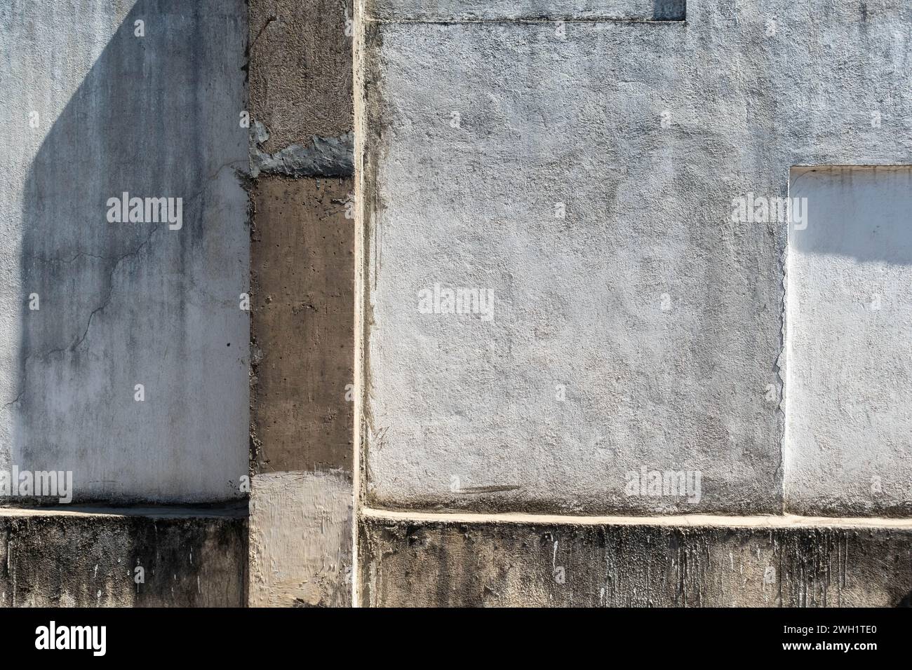 Stark contrast of light and shadow across a textured concrete wall ...