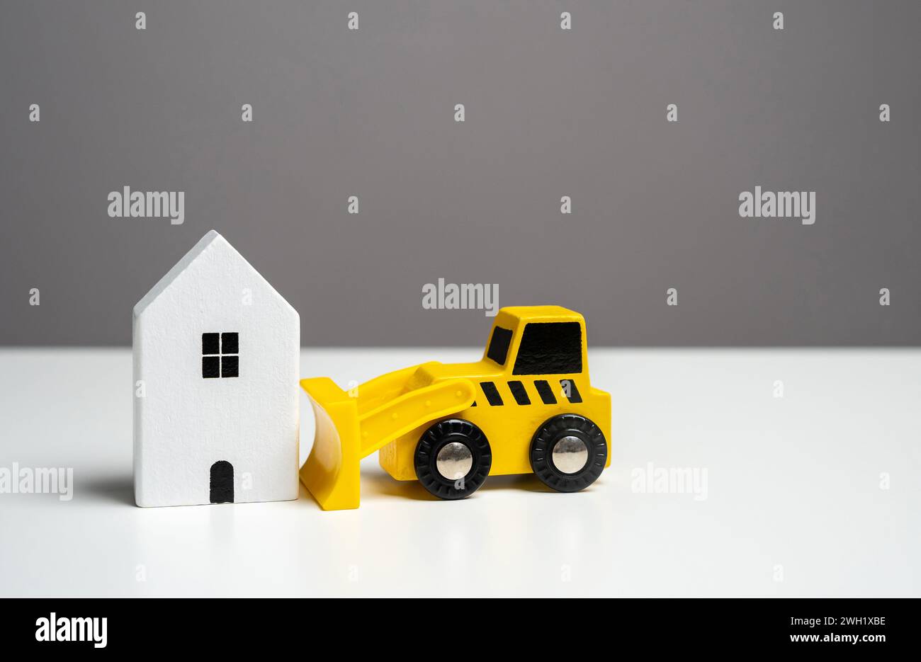 The bulldozer intends to demolish the house. Tearing down a house ...