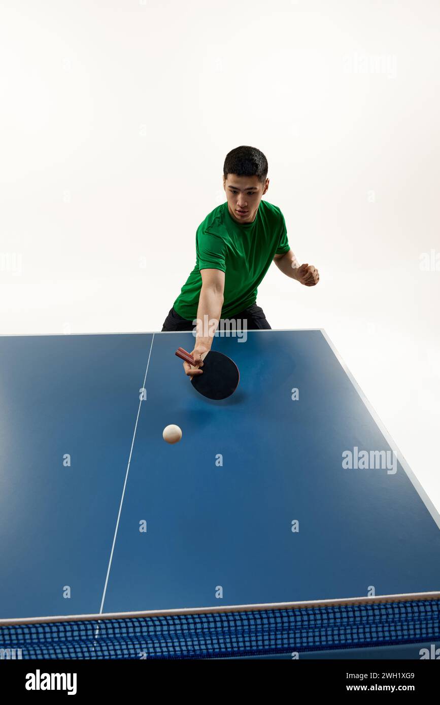 Concentrated athlete, Asian man with paddle ready for table tennis shot ...