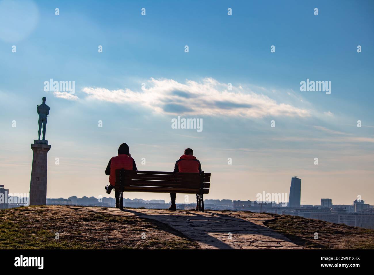 Two friends outdoors on nice sunny day, sitting on the bench at ...