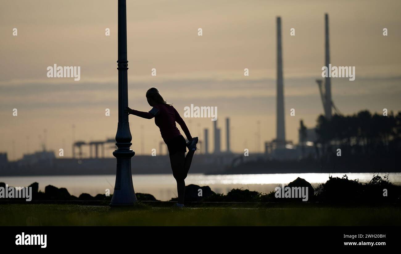 A runner stops to stretch as she exercises on the strand in Clontarf ...