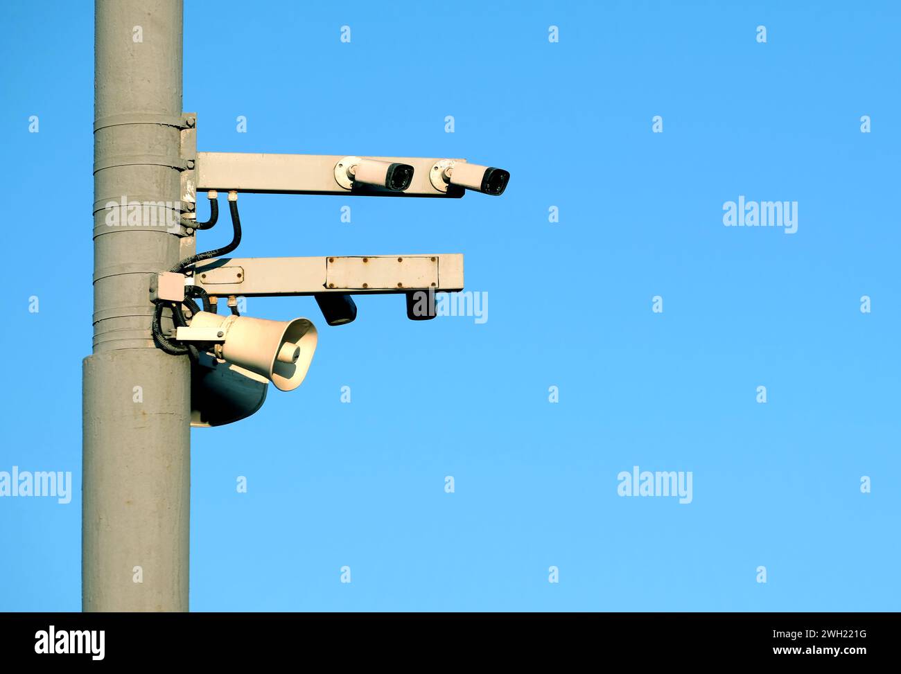 Safety road traffic cameras mounted on the pole against clear blue ...