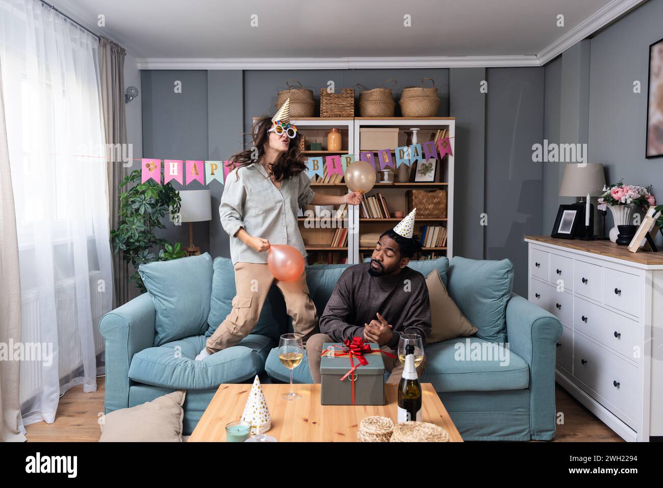 Young woman jumping on sofa hi-res stock photography and images - Alamy