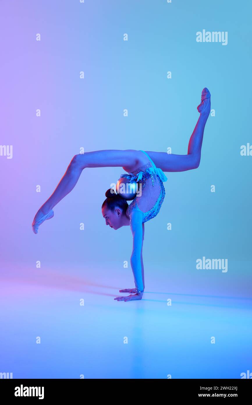 Flexible teen girl in sparkling costume, rhythmic gymnast performing ...