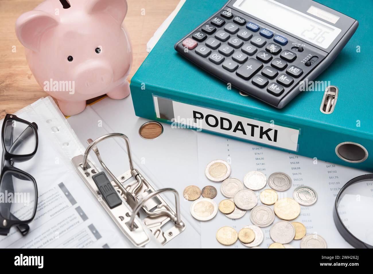 Polish tax concept with coins and calculator. Binder with Podatki means ...