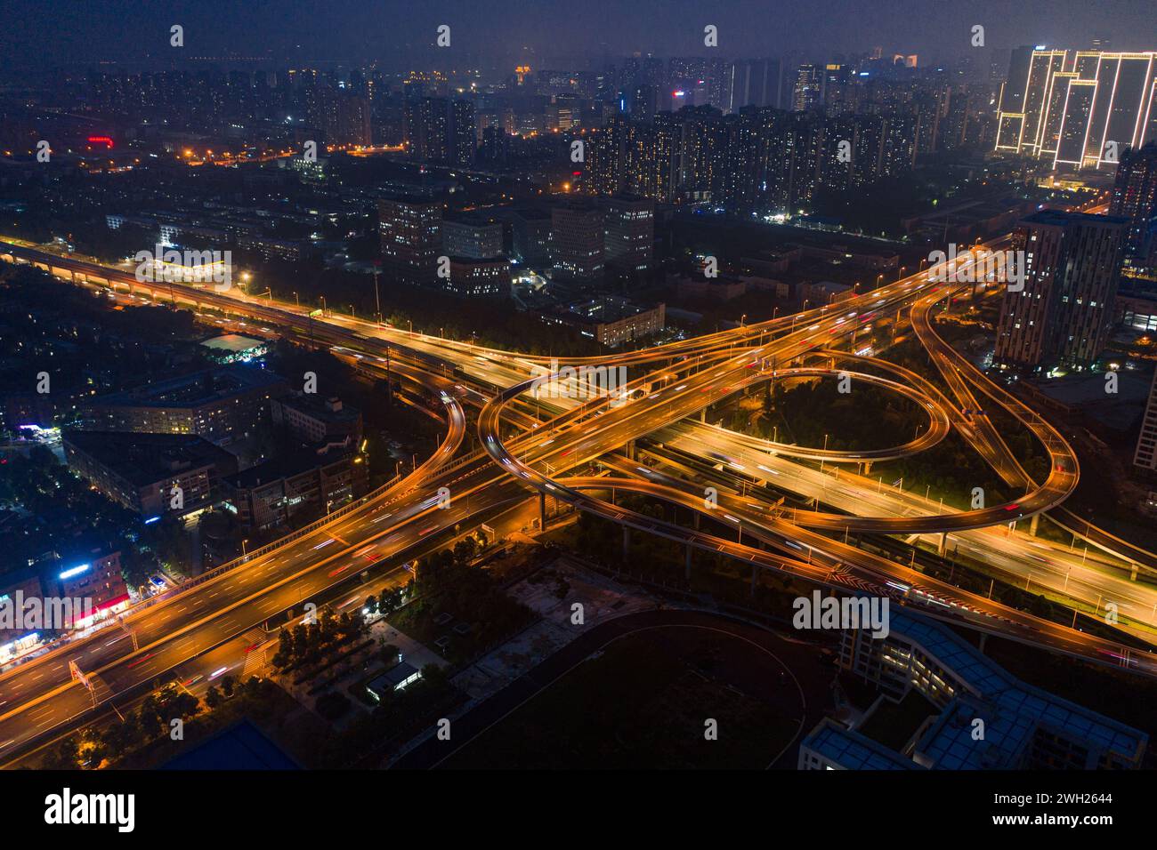 An aerial view of an intersection illuminated by orange-yellow street ...