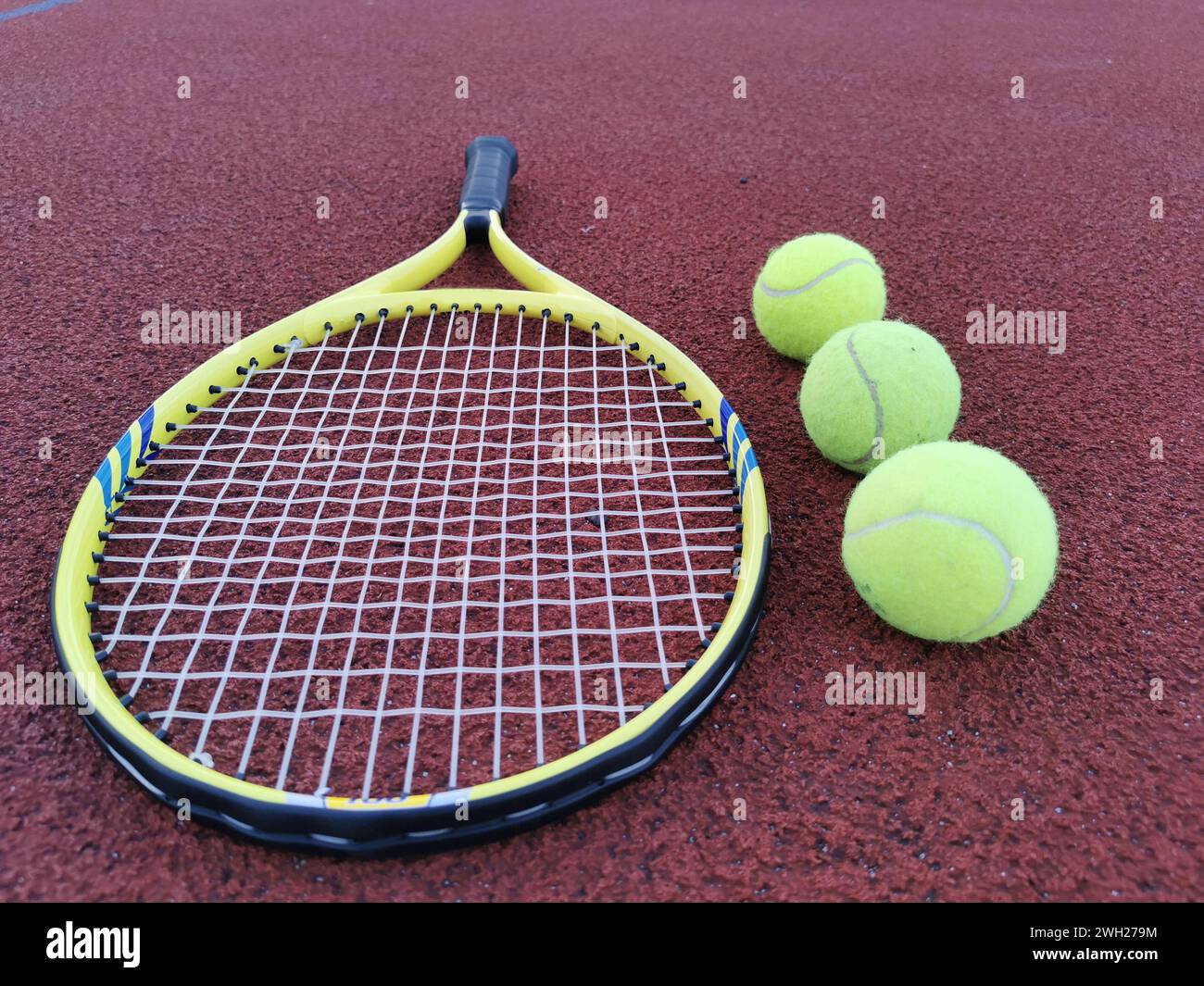 Tennis. Tennis ball and racket on a red background of tennis court with ...