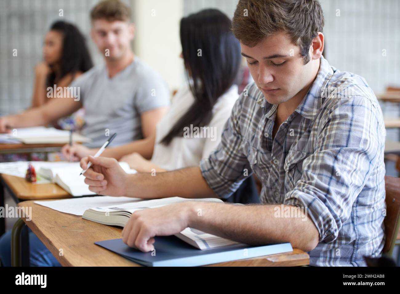 University, book and man in class reading with ambition for development in learning, opportunity ...