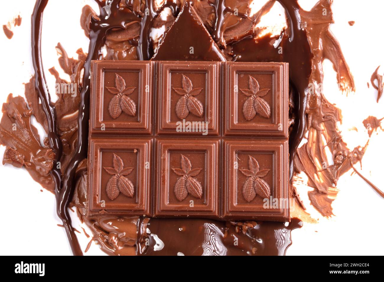 Sweet melted chocolate background with chocolate squares on which cocoa ...