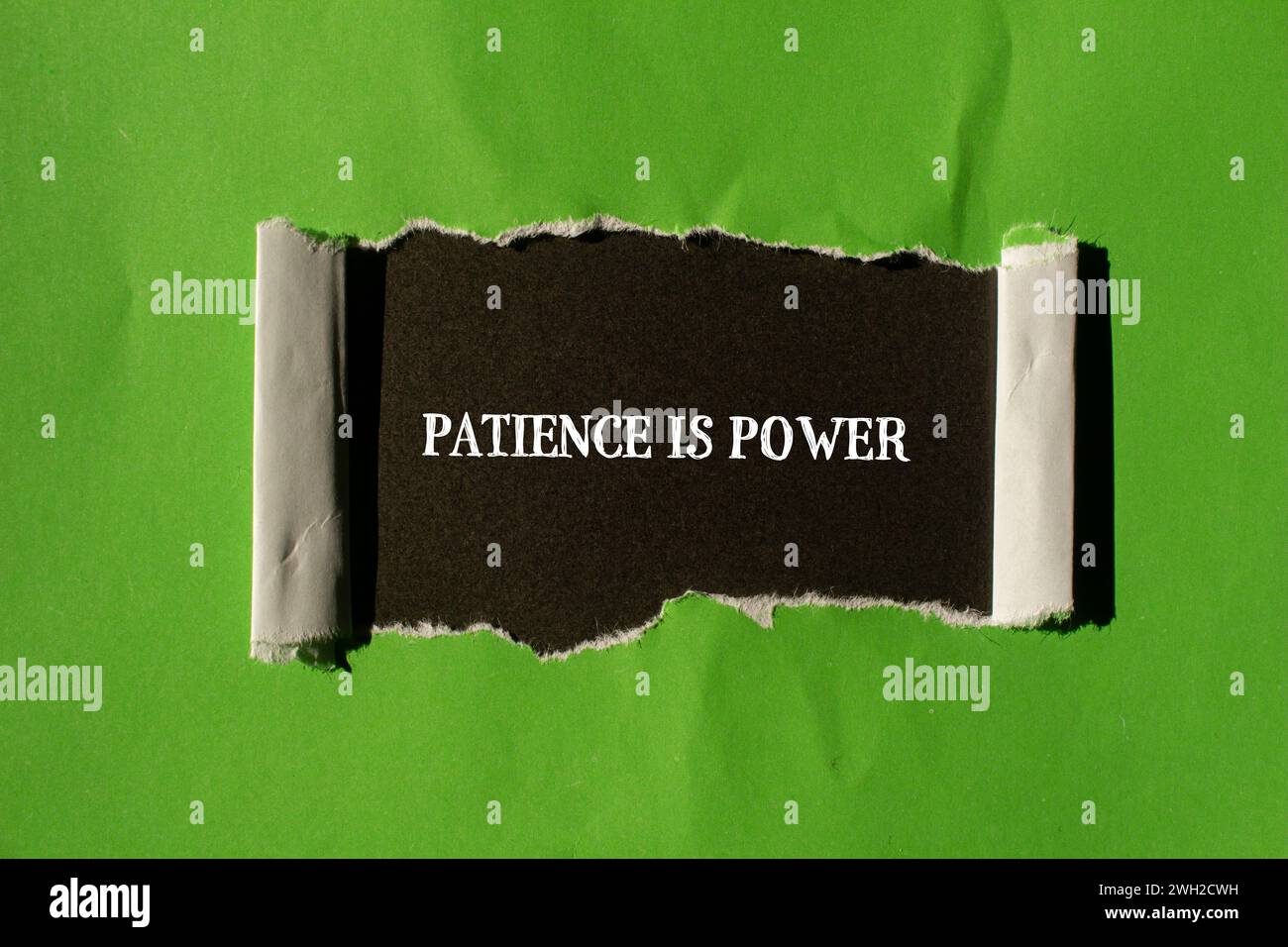 Patience is power lettering on ripped green paper with black background ...