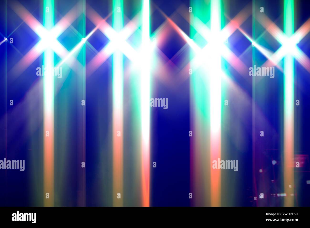 Bright festive multi-colored stage lighting with optical flare and rays ...