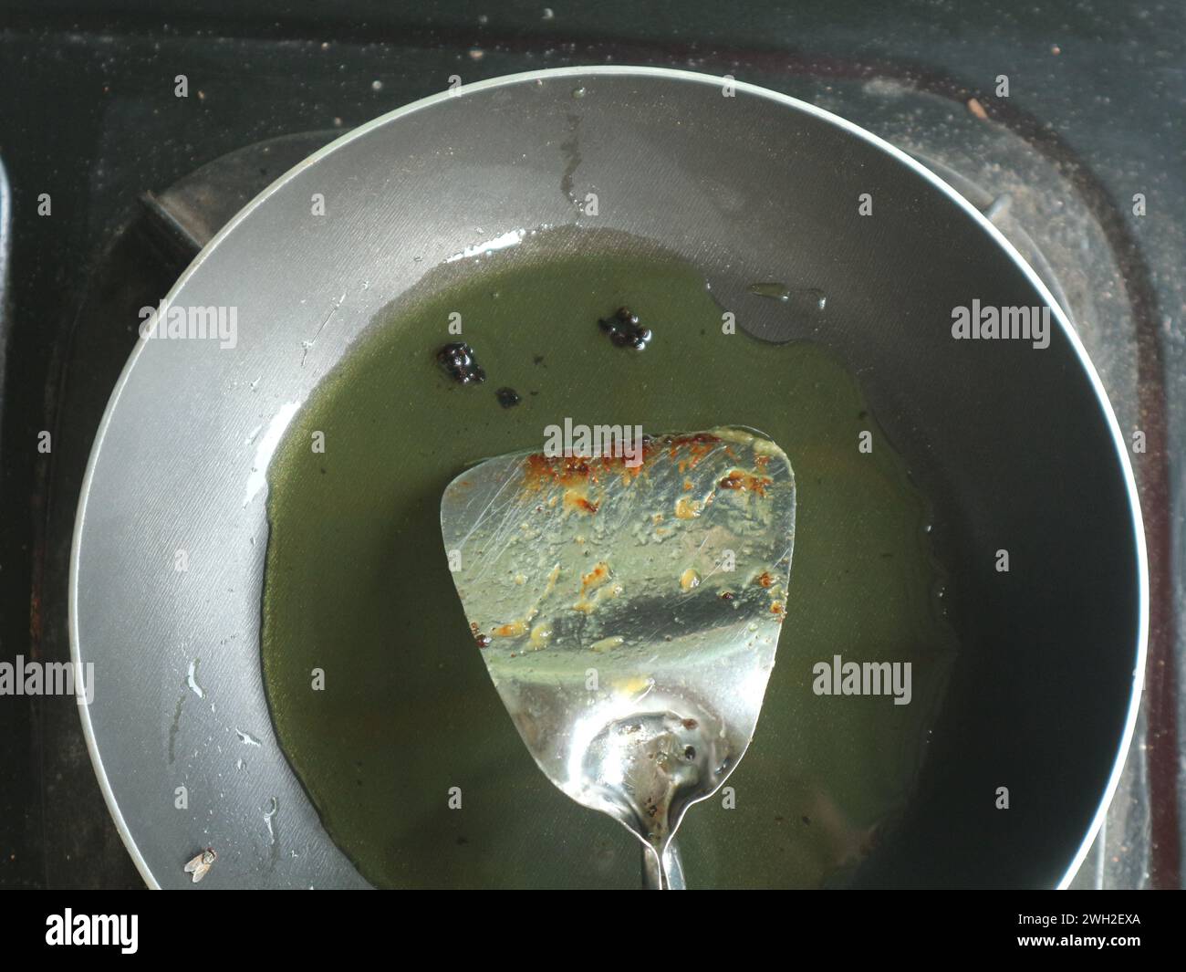 The container used for frying still has used oil and a spatula left ...