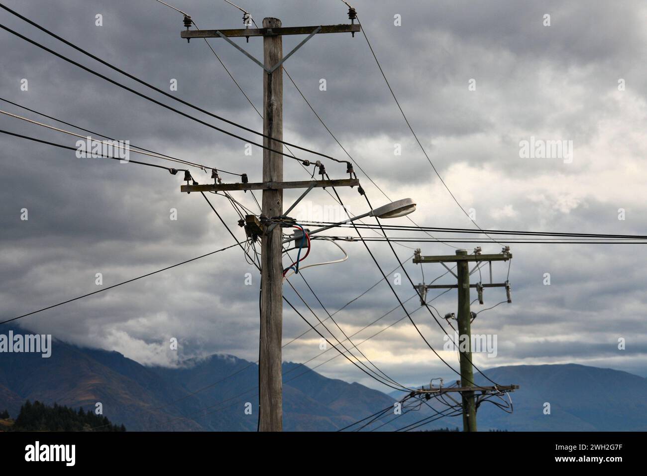 Electric grid in New Zealand. Wooden electric poles in Queenstown Stock ...