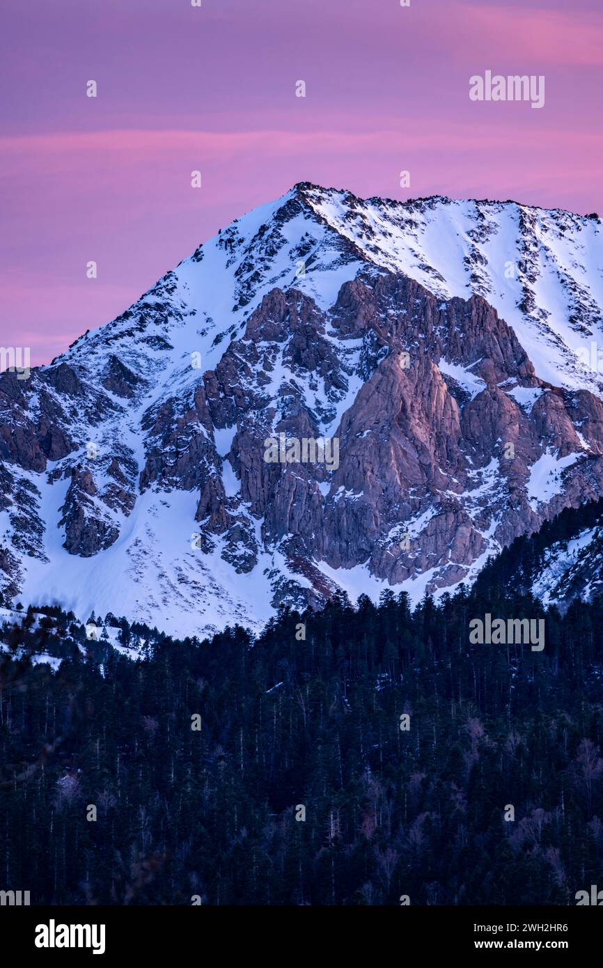 Sunset casts orange hues on snow-clad Roc Blanc peak, Ariège Pyrenees ...