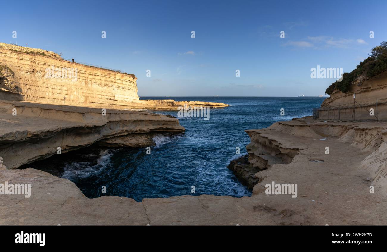 warm evening light over the landmark of St. Peter's Pool at Delimara ...