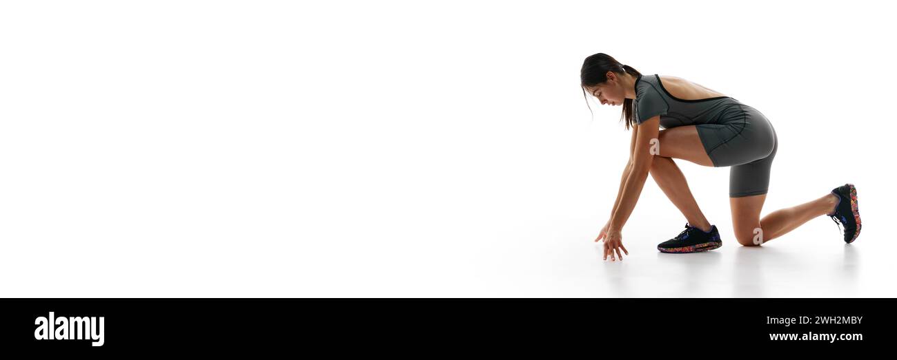 Ready, steady, go. Female runner athlete in grey jumpsuit, sportswear ...