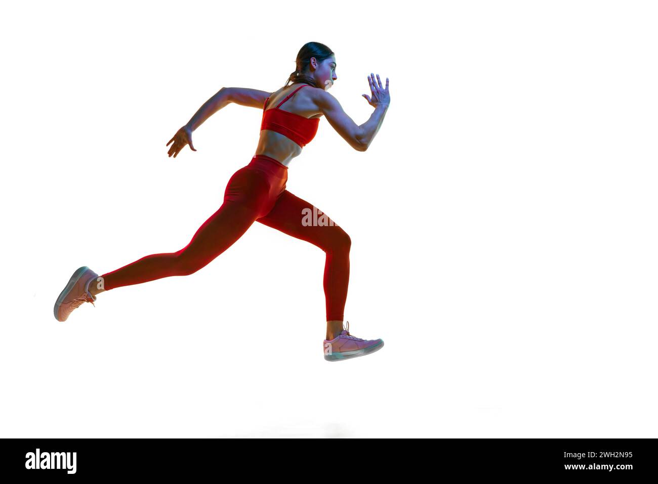 Competitive, concentrated young woman, runner, athlete in motion ...