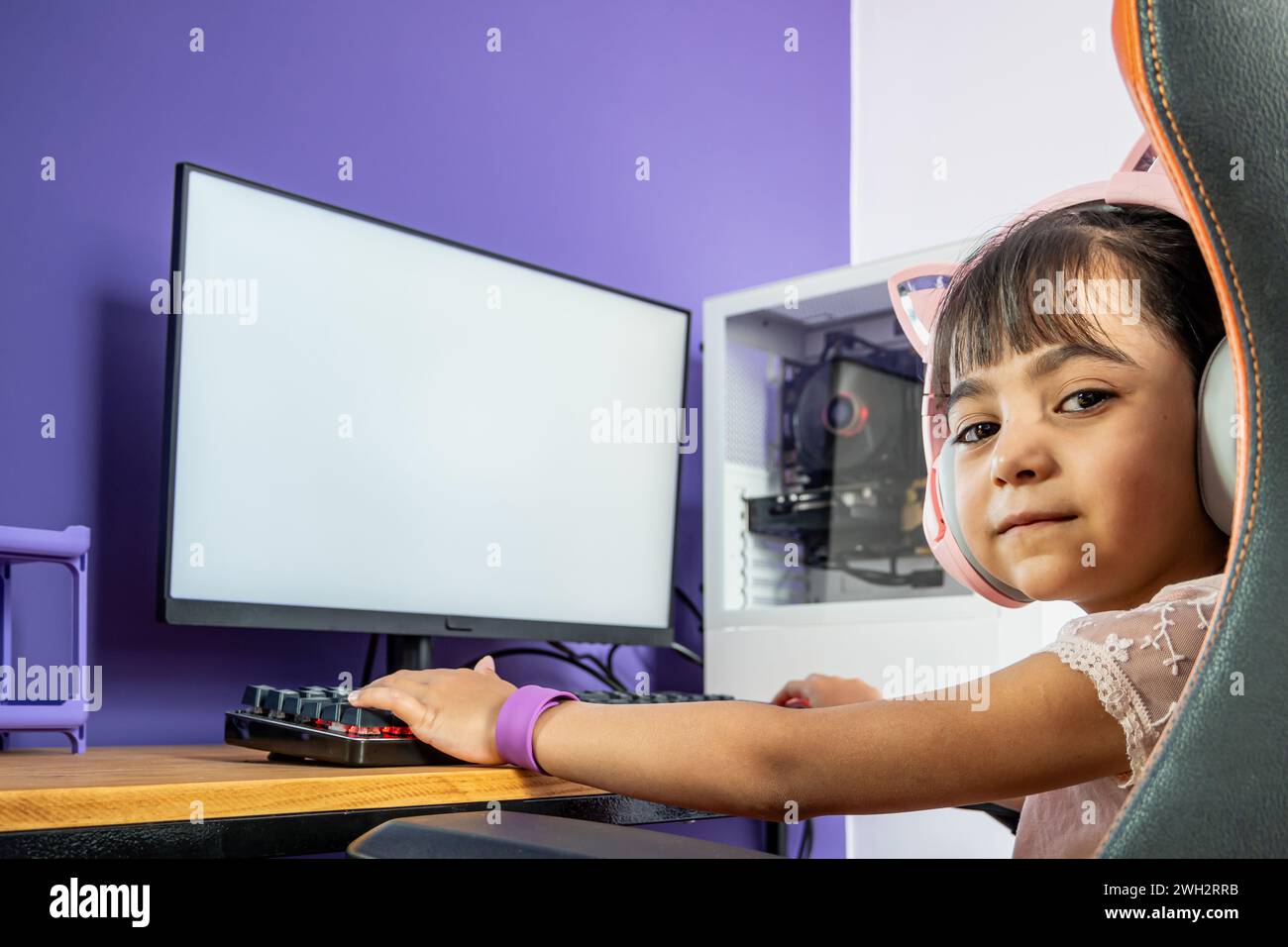 Gamer girl with headphones in front of the computer. She is a childish ...