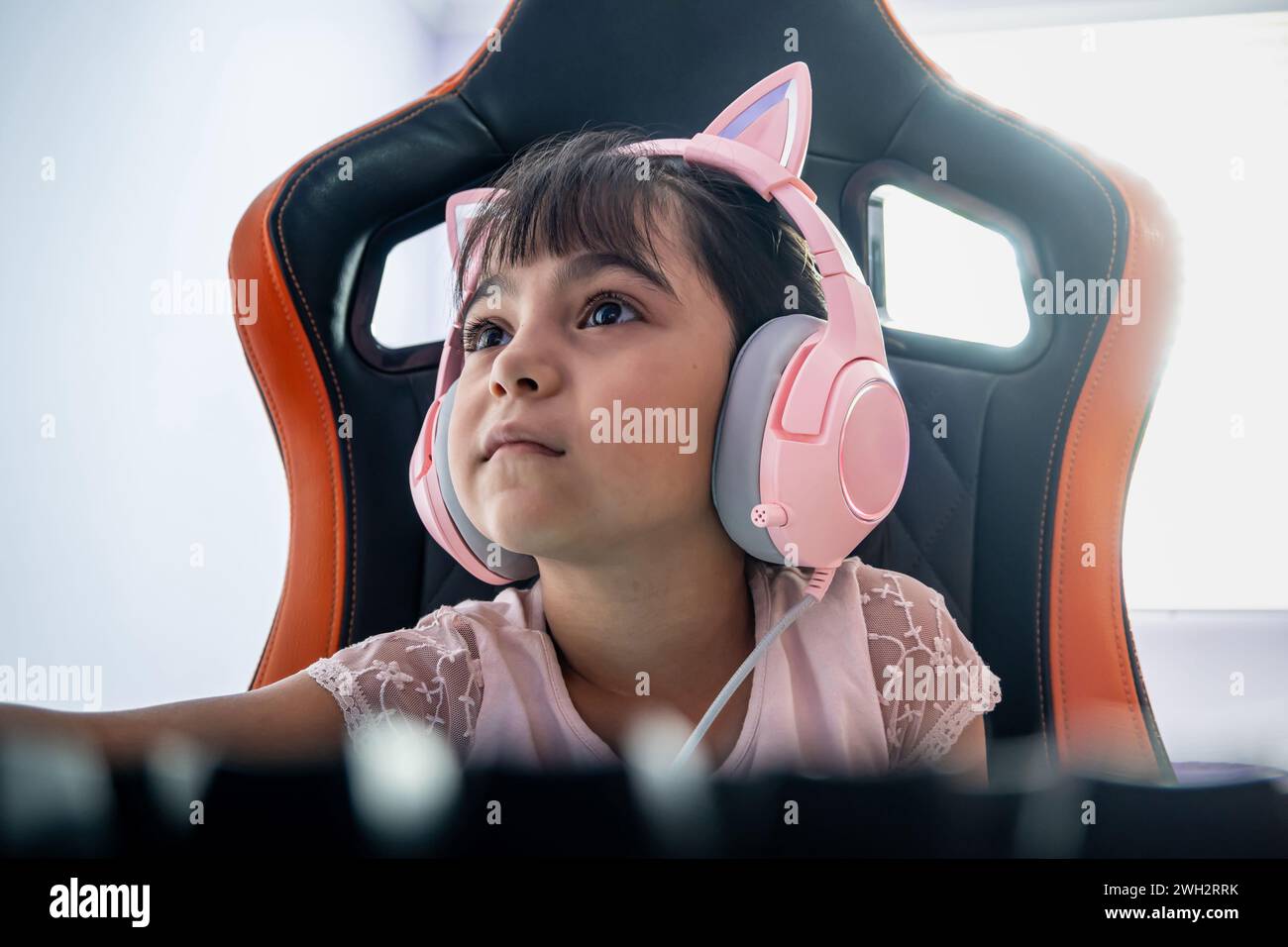 Adorable gamer girl playing on the computer in the bedroom. She is a ...
