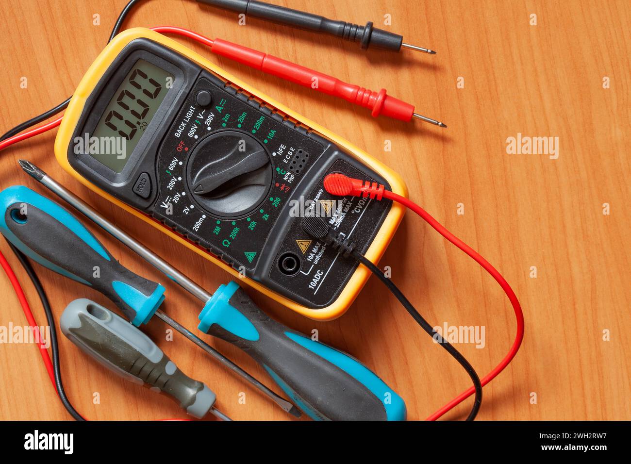 Digital multimeter and screwdrivers on table. Maintenance and repair ...